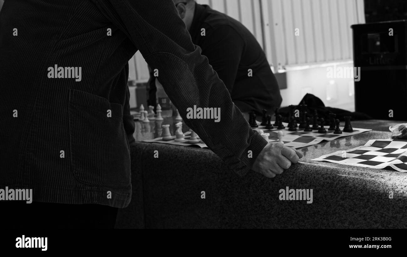 A man leaning over a chess game while deep in thought Stock Photo - Alamy