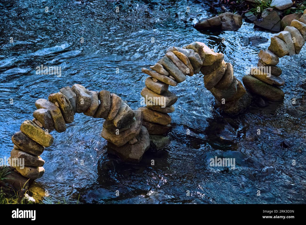The arched decorative park bridge is built of stones (flat pebbles ...