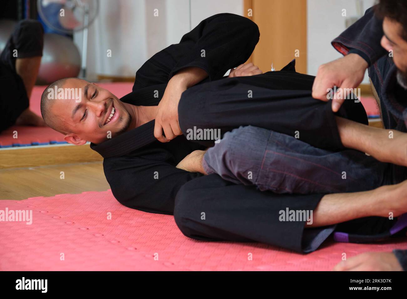 Two men practicing Brazilian Jiu-Jitsu sparring at the Academy Stock ...