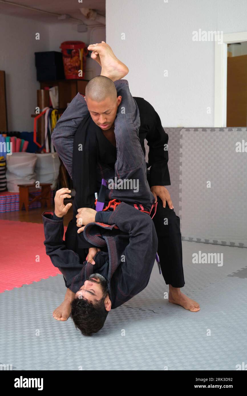 Two men practicing Brazilian Jiu-Jitsu sparring at the Academy Stock ...