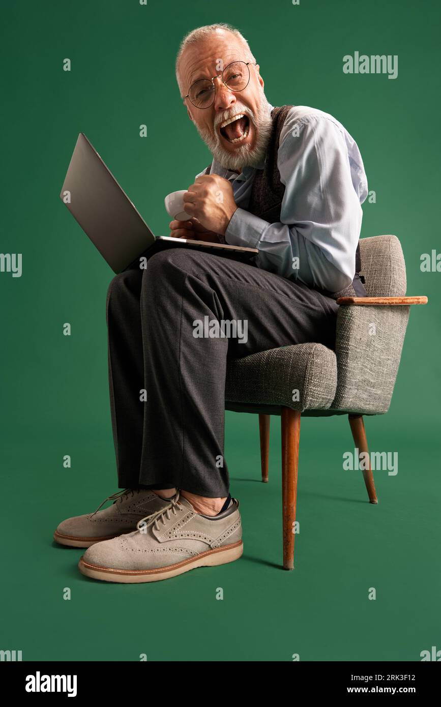 Full length portrait of senior man with beard in glasses, wearing ...