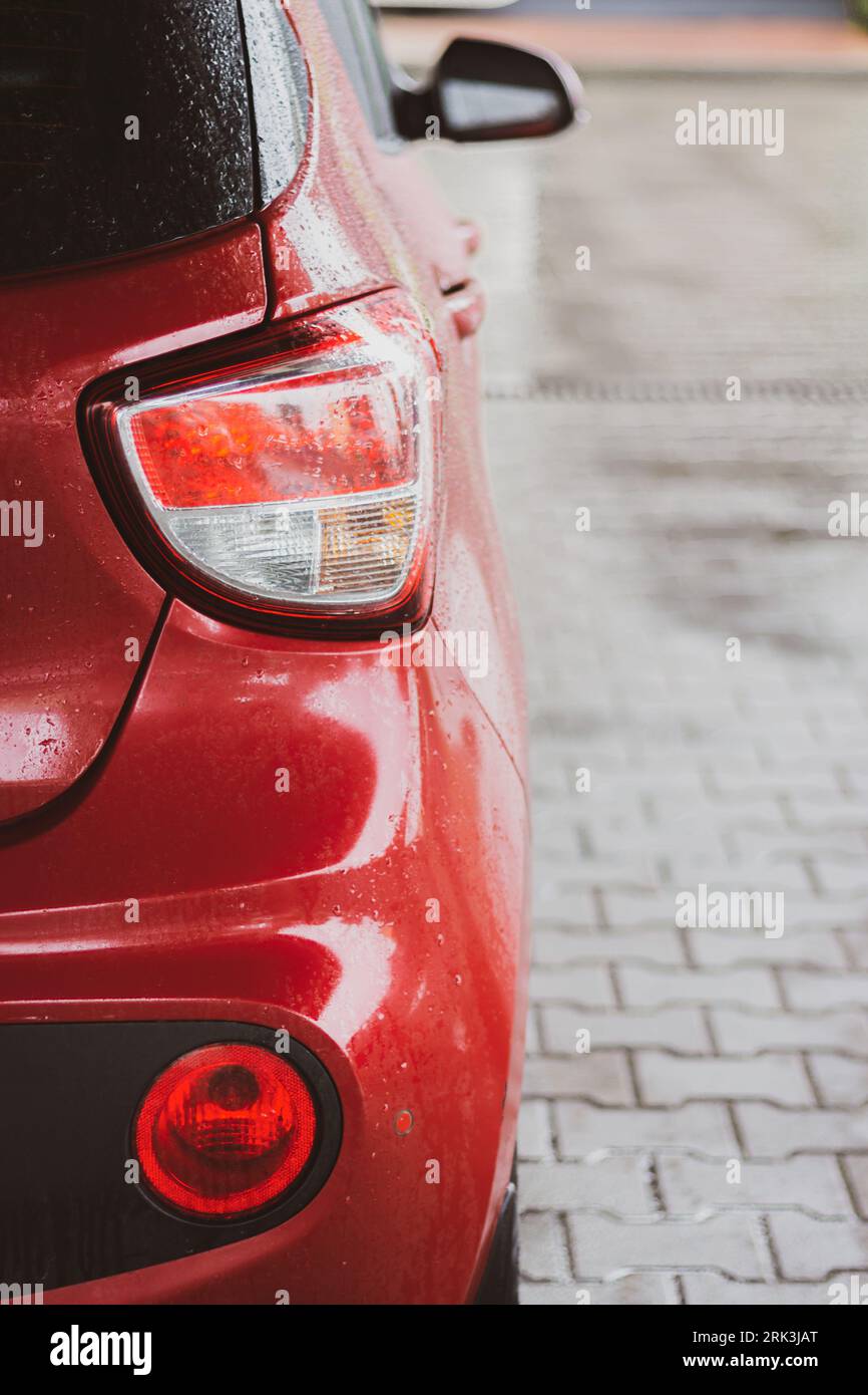 Red car with tail lights. Car parking in backyard. Red hatchback car ...