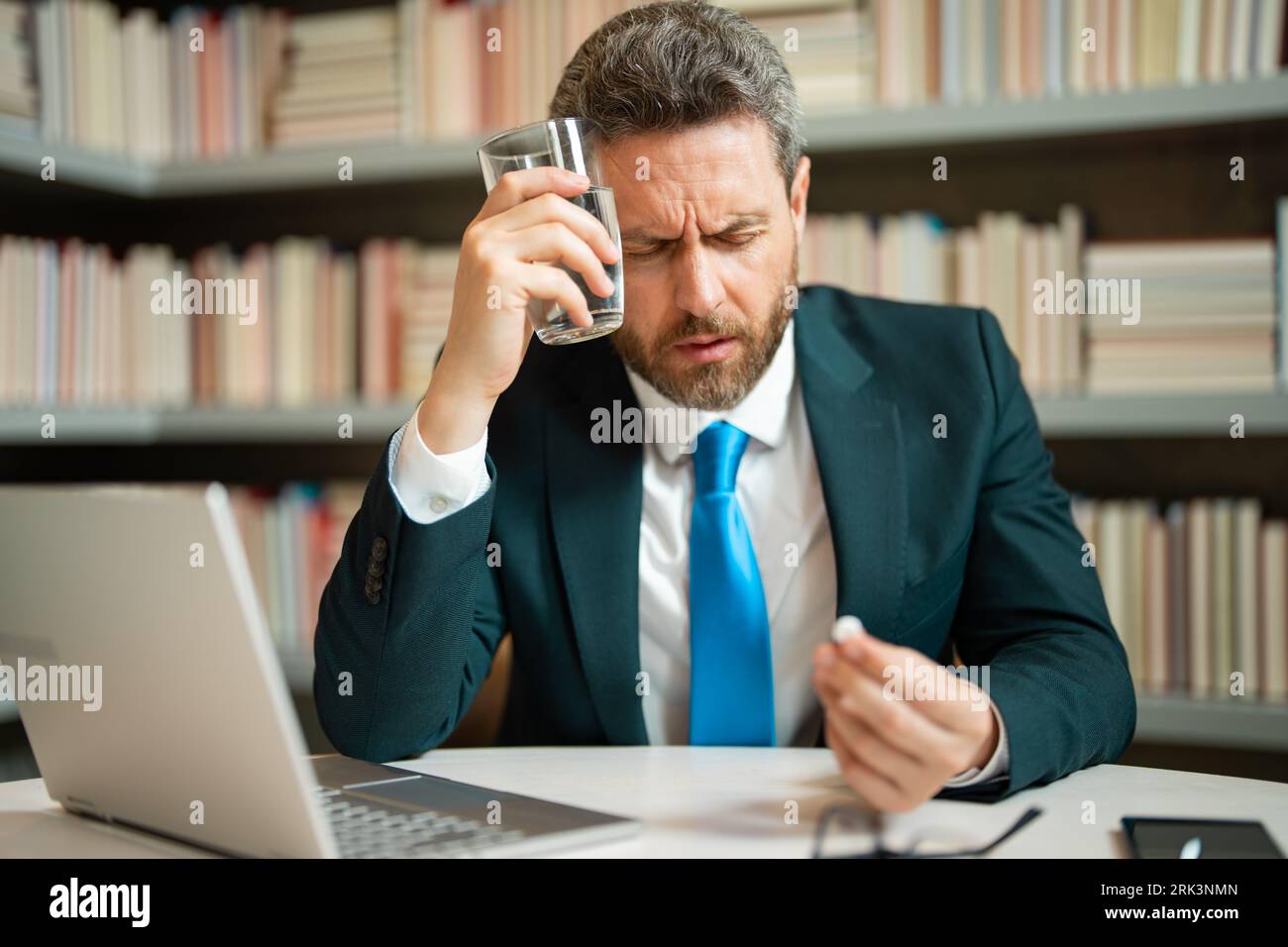 Headache and eye strain on laptop. Business man with stress and fatigue ...