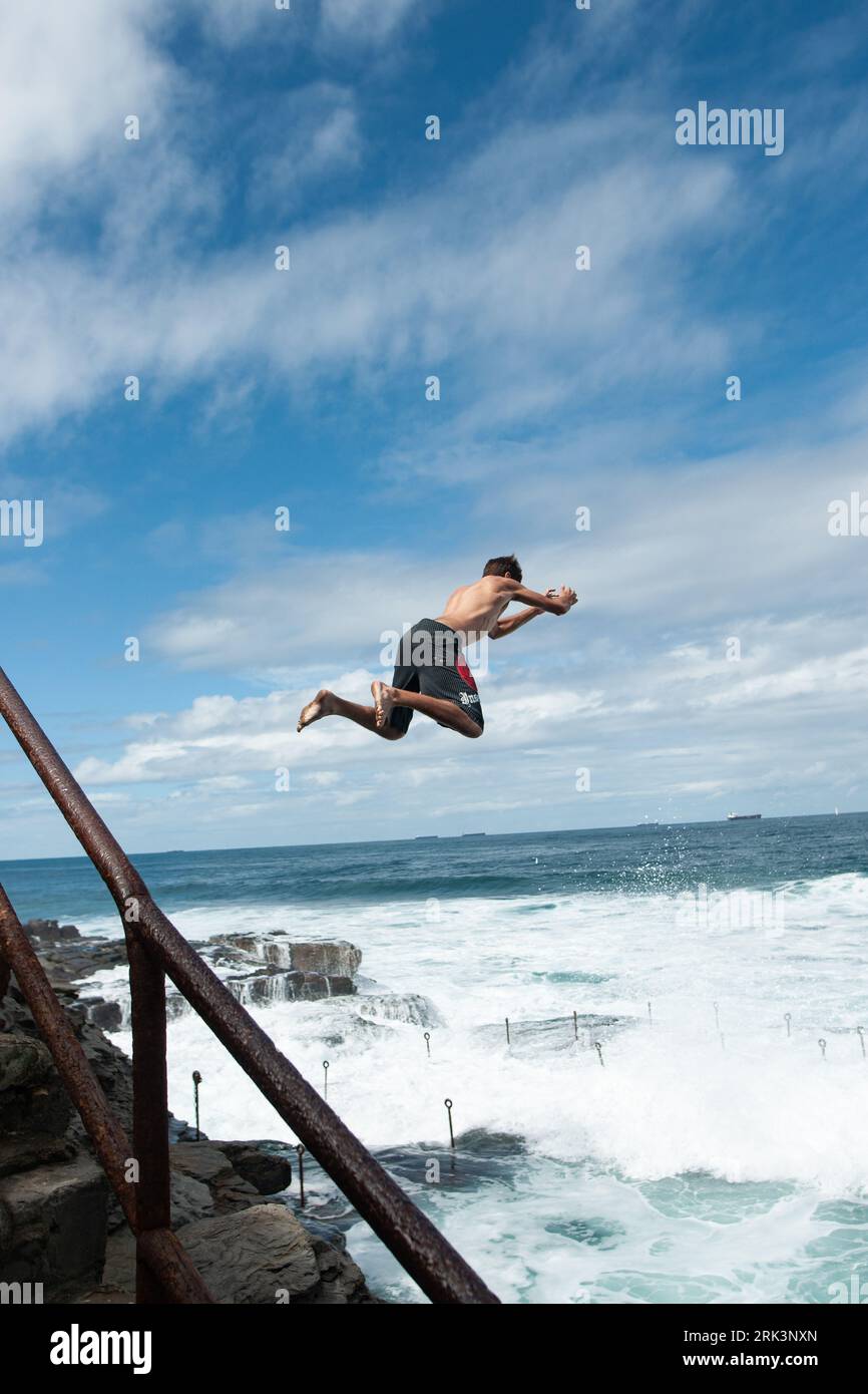 a group of teenage boys jumping into and play in a natural rock pool in newcastle nsw Stock ...