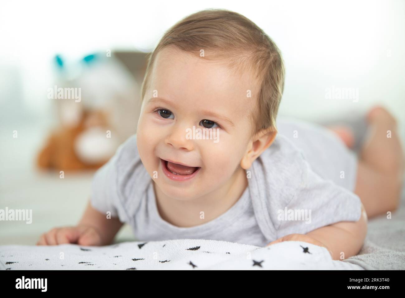 adorable contented baby lying on bed Stock Photo - Alamy