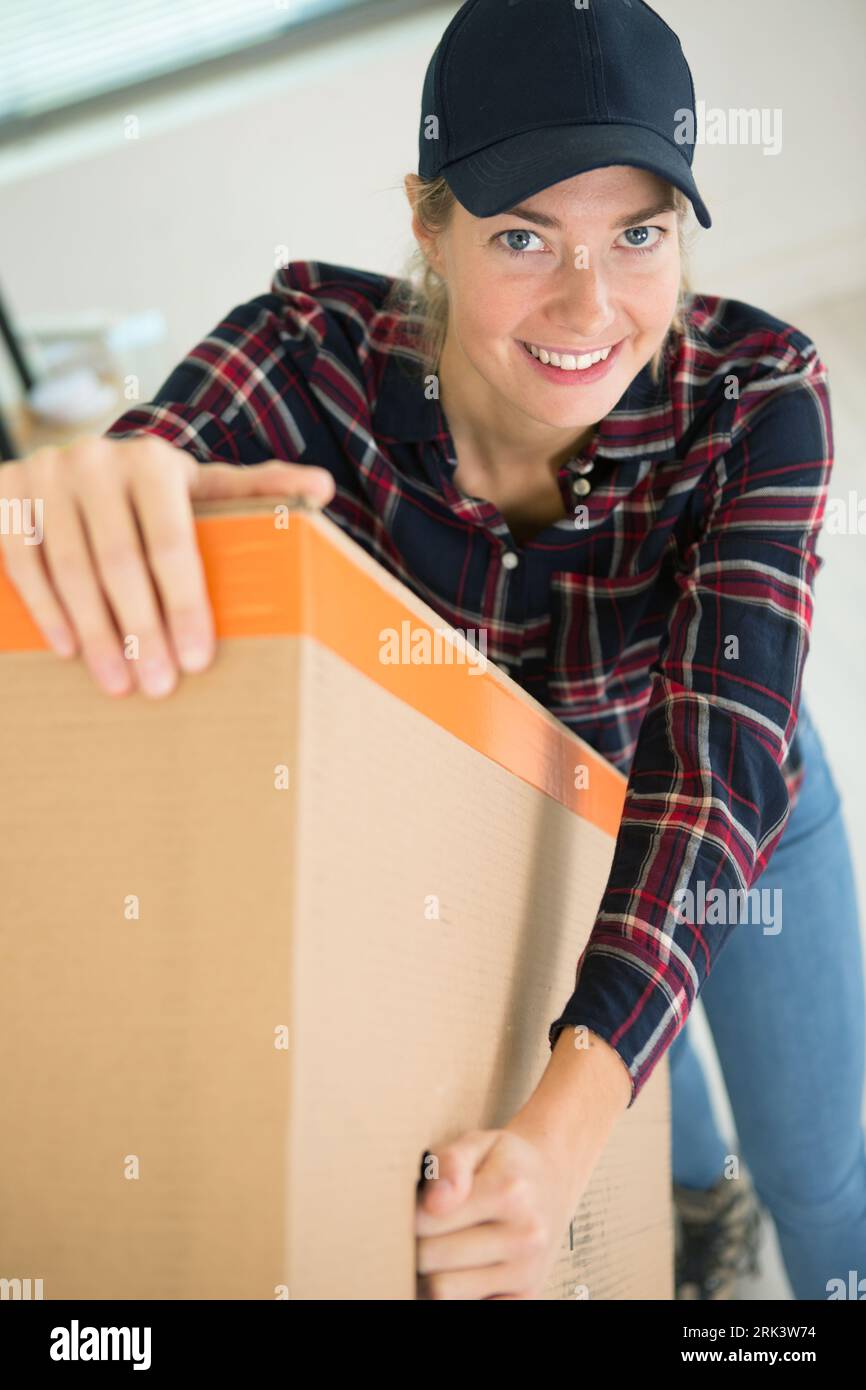 female courier moving bulky box Stock Photo - Alamy