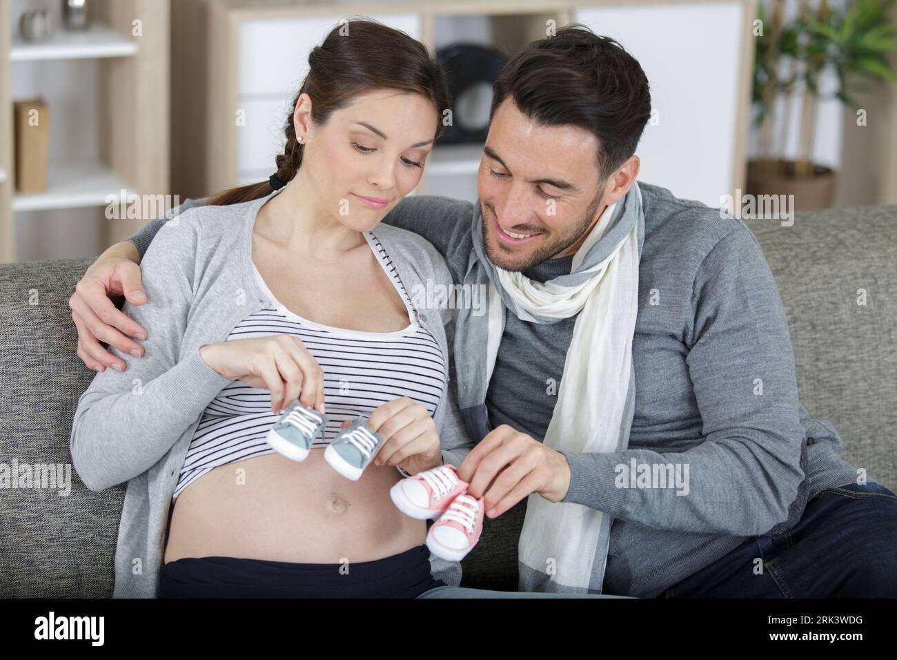 happy pregnant parents holding colorful baby boots Stock Photo - Alamy