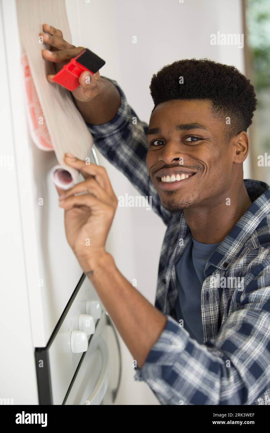 handyman applying blue for a wallpaper Stock Photo - Alamy