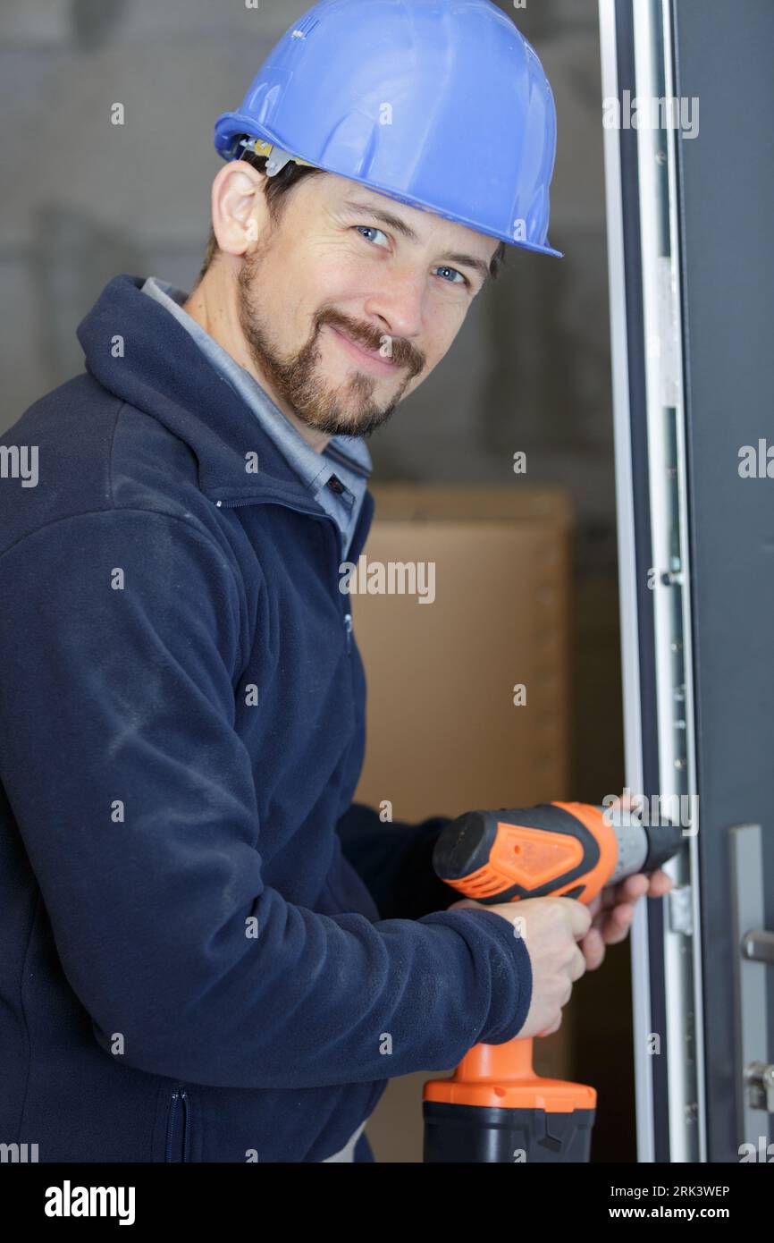 construction worker using cordless drill on door frame Stock Photo - Alamy