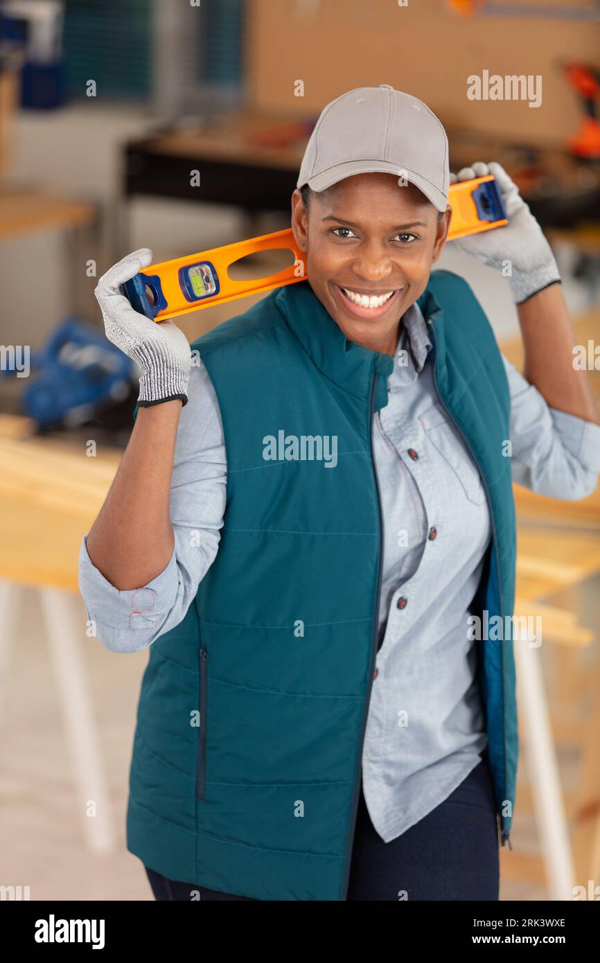 female construction worker carrying level Stock Photo - Alamy