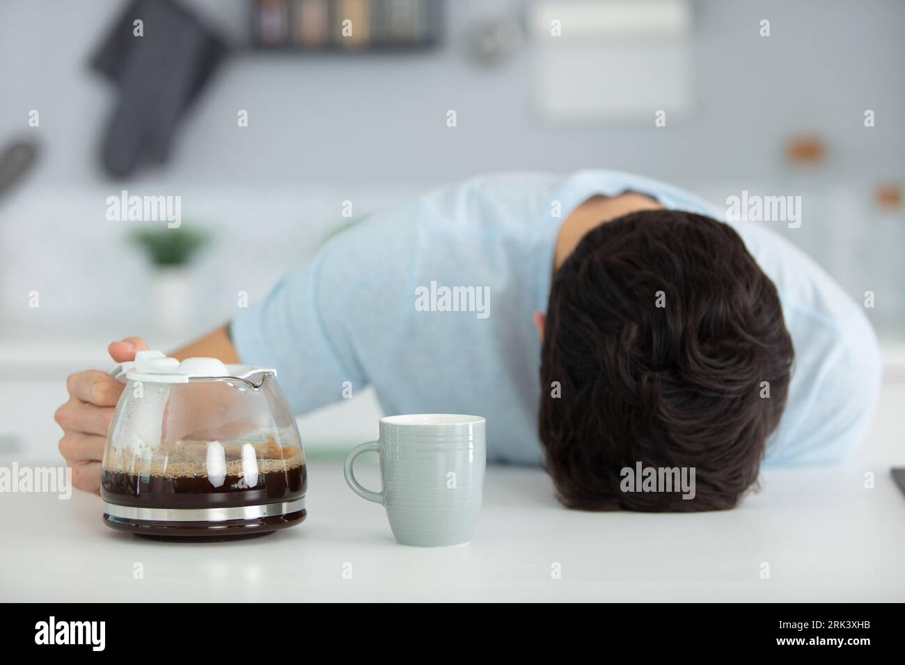 tired man sittingwith jug of coffee and sleeping Stock Photo - Alamy