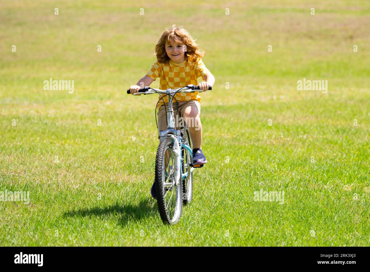 Little kid boy ride a bike in the park. Kid cycling on bicycle. Happy ...