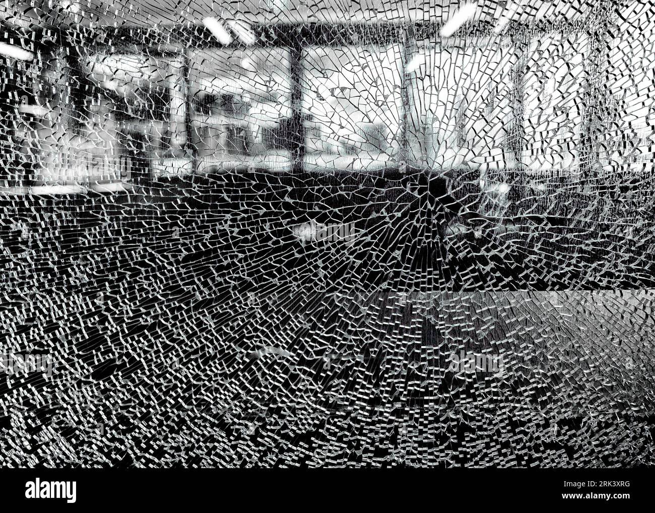 A black and white image of smashed/shattered sheet of safety glass ...