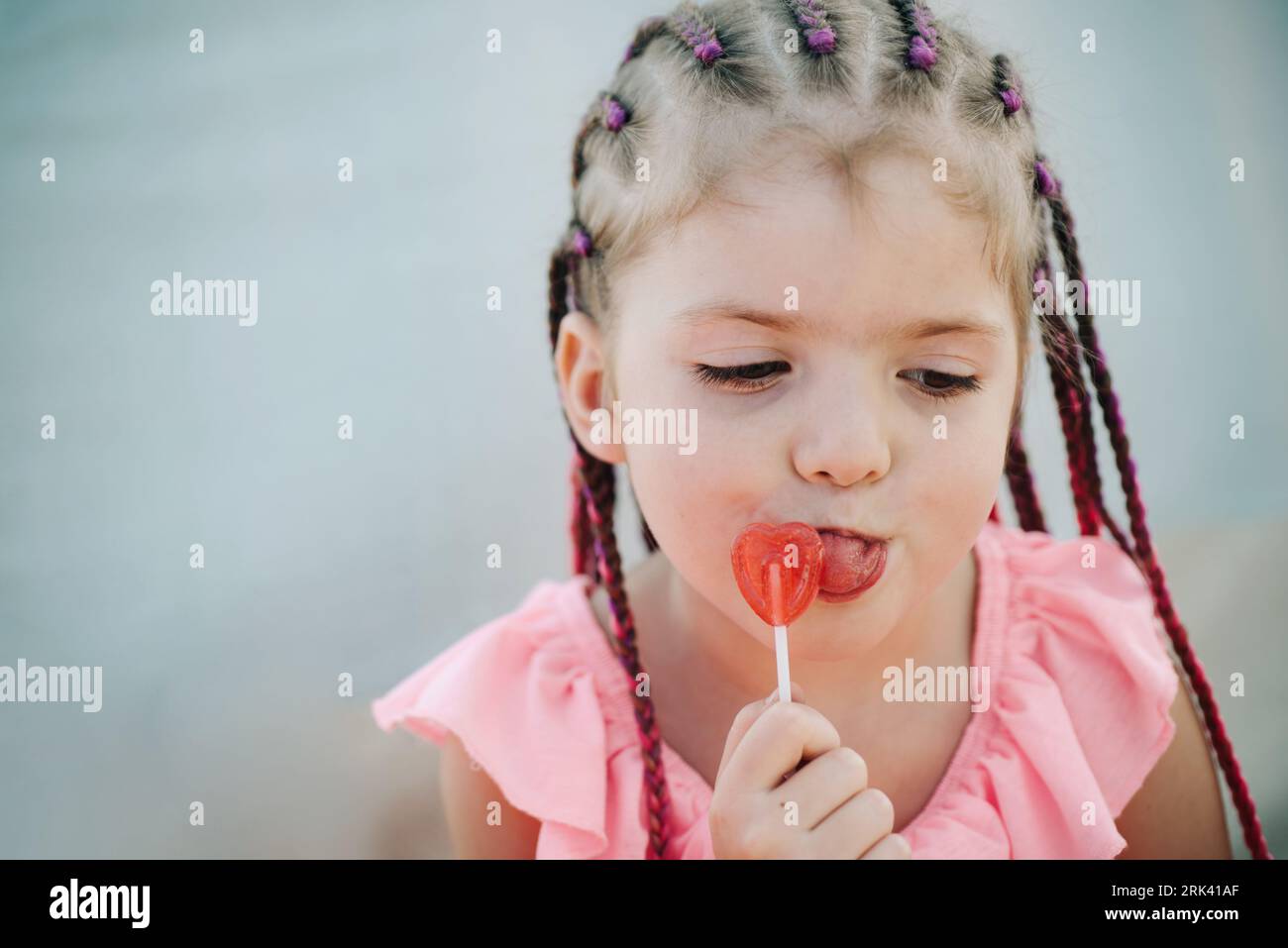 Little girl lick lollipop. Lifestyle closeup portrait of funny kids ...