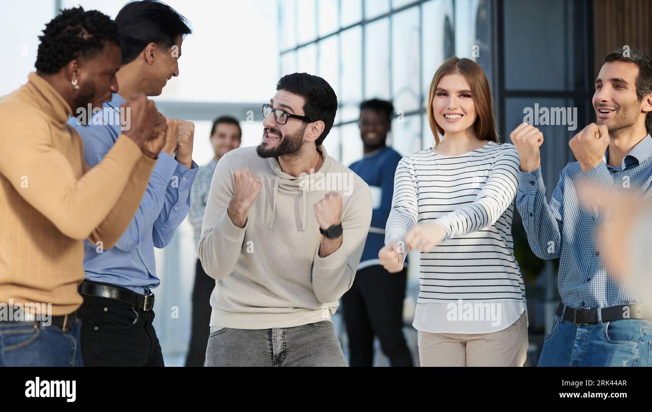 Business people celebrates and clench their fists in the air as a ...