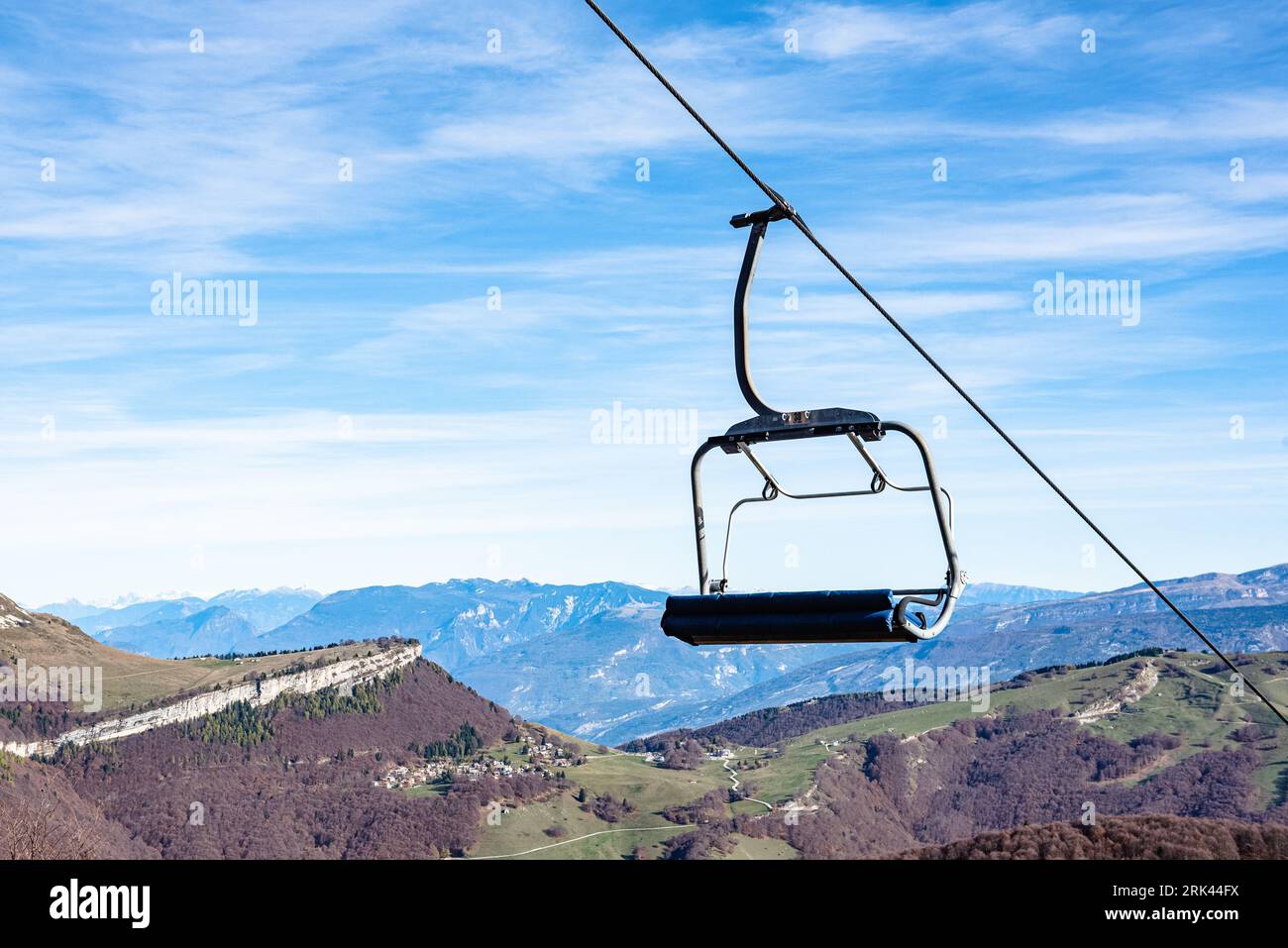 An aerial view of an empty ski lift in a mountainous landscape, rising ...