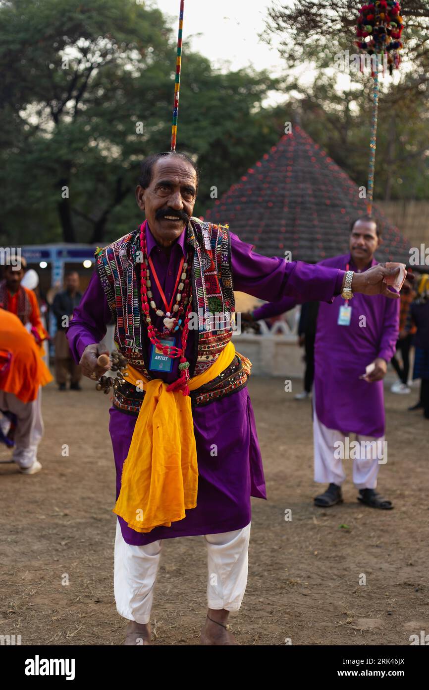 A group of folk dancers dressed in traditional clothing from Sindh ...