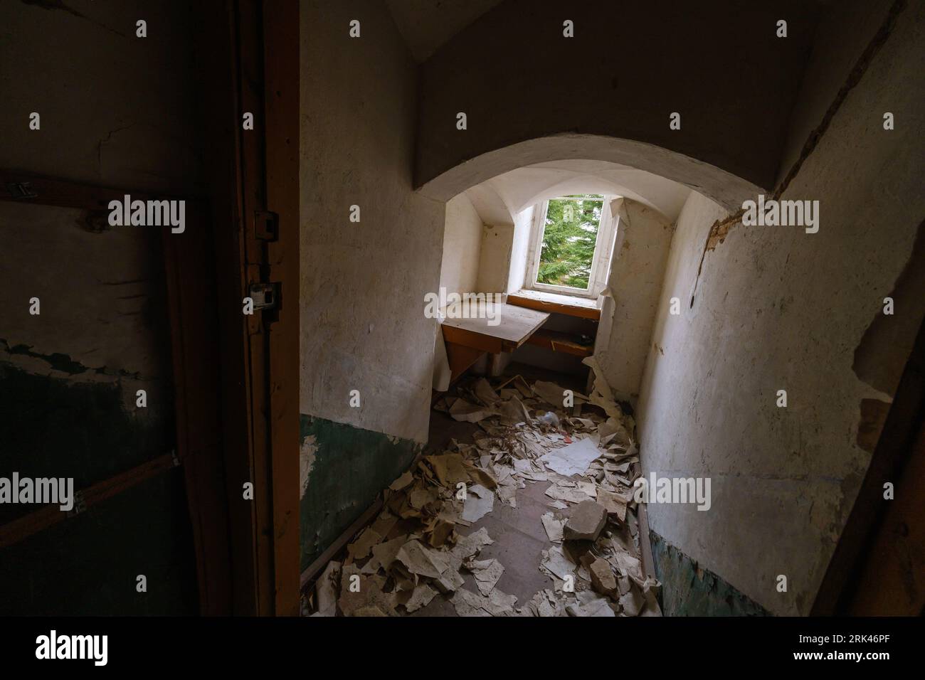 High angle of narrow passage with shabby stone walls arched ceiling and ...