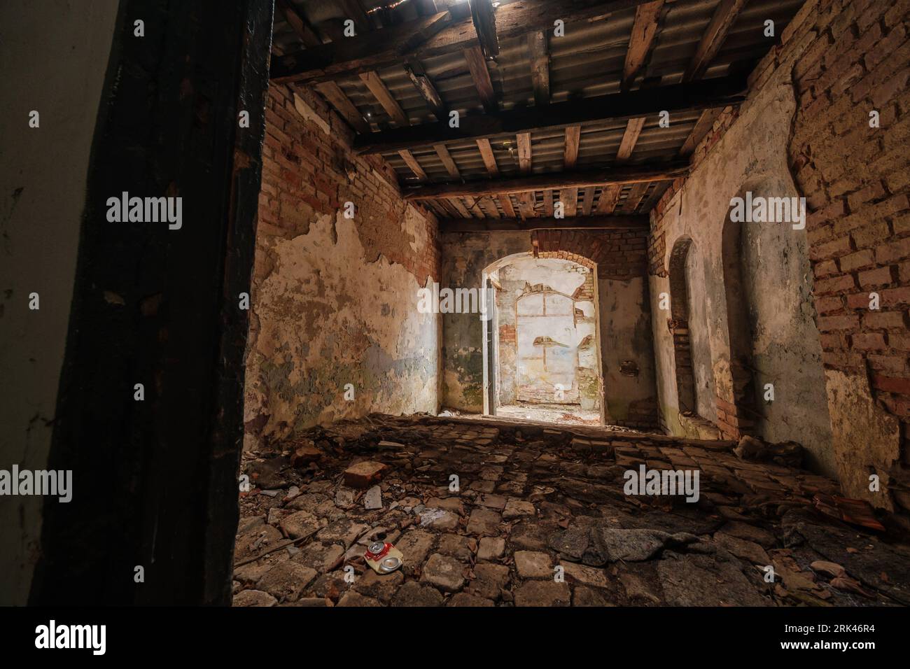 Old room with broken ceiling shabby brick walls and arched doorway ...
