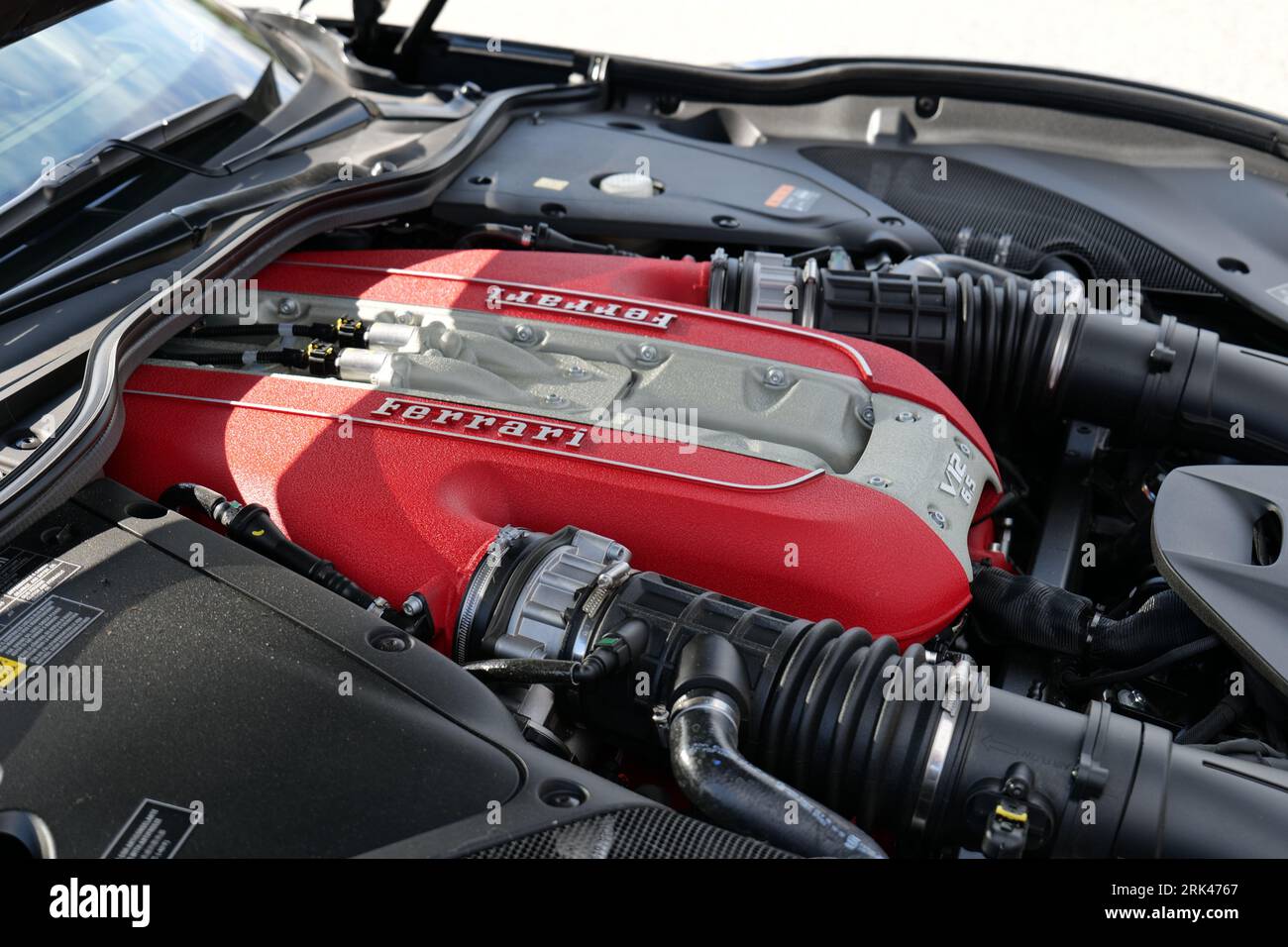 A close-up of a red Ferrari engine in a sleek, black car Stock Photo ...