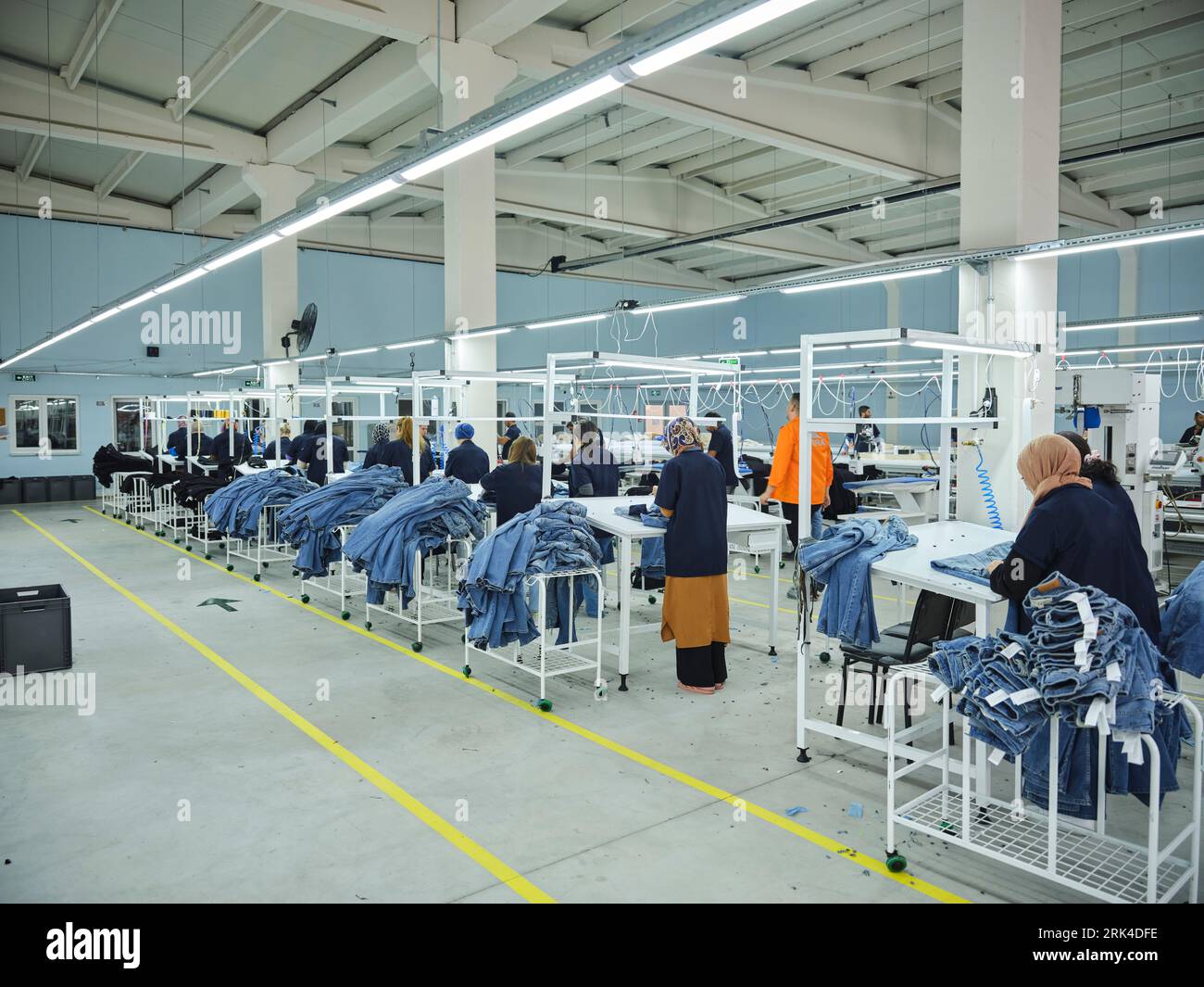 several sewing machines. Tailoring industry. jean making factory. jean sewing. worker working ...