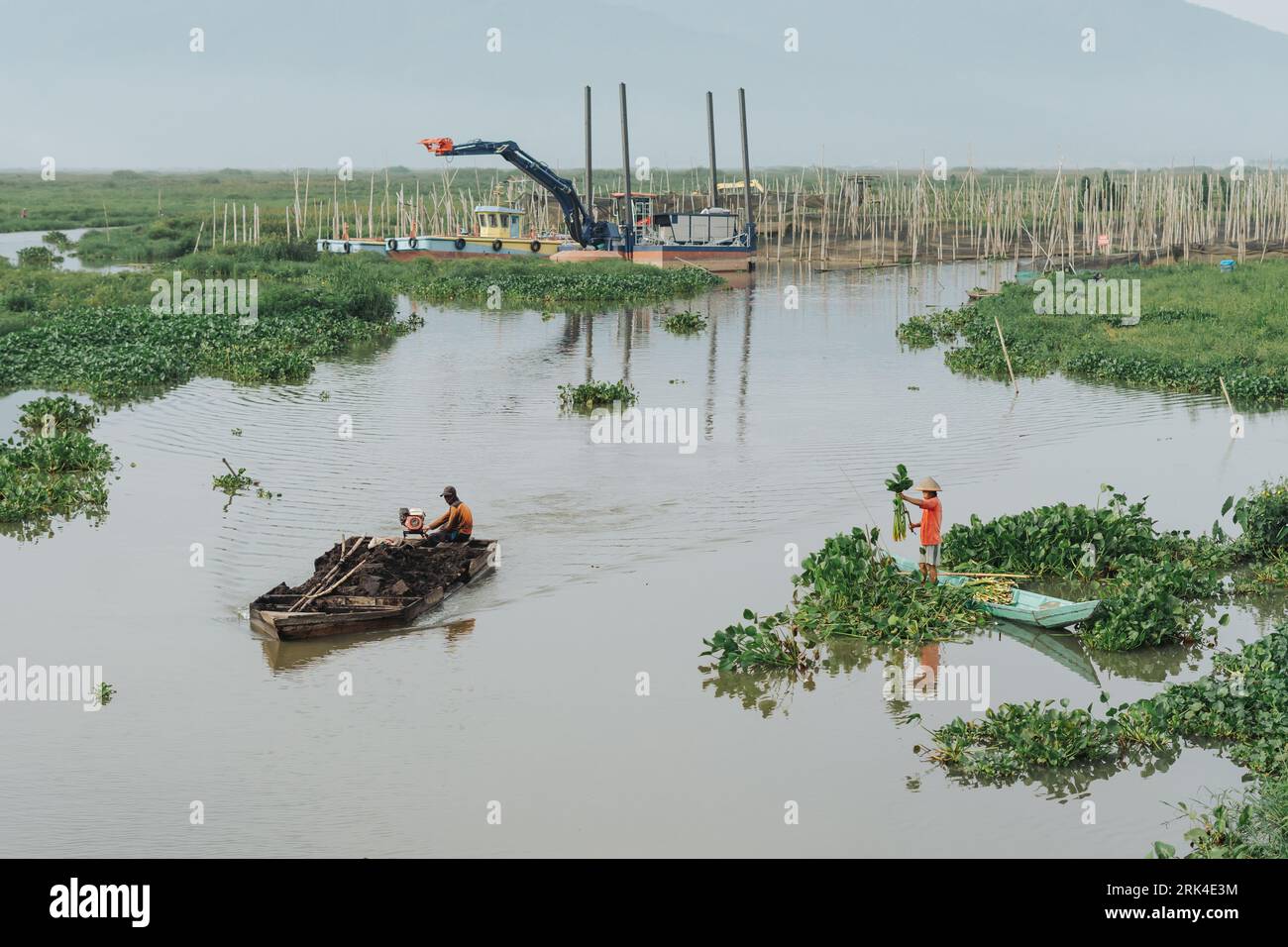A miner transport peat soil by boat on Rawa Pening lake in Semarang ...