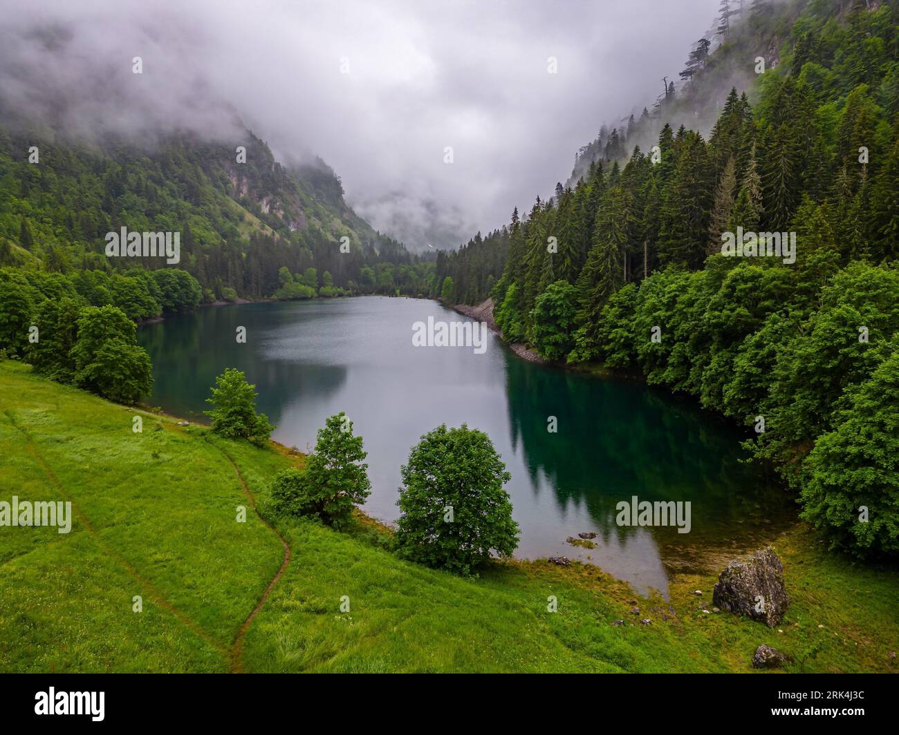 A picturesque view of Lake Susica surrounded by cloudy mountains Stock ...