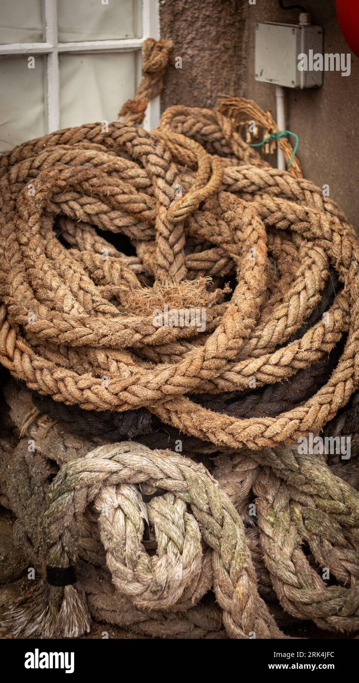A close-up of tan-colored, thick ropes near a closed brown window Stock ...