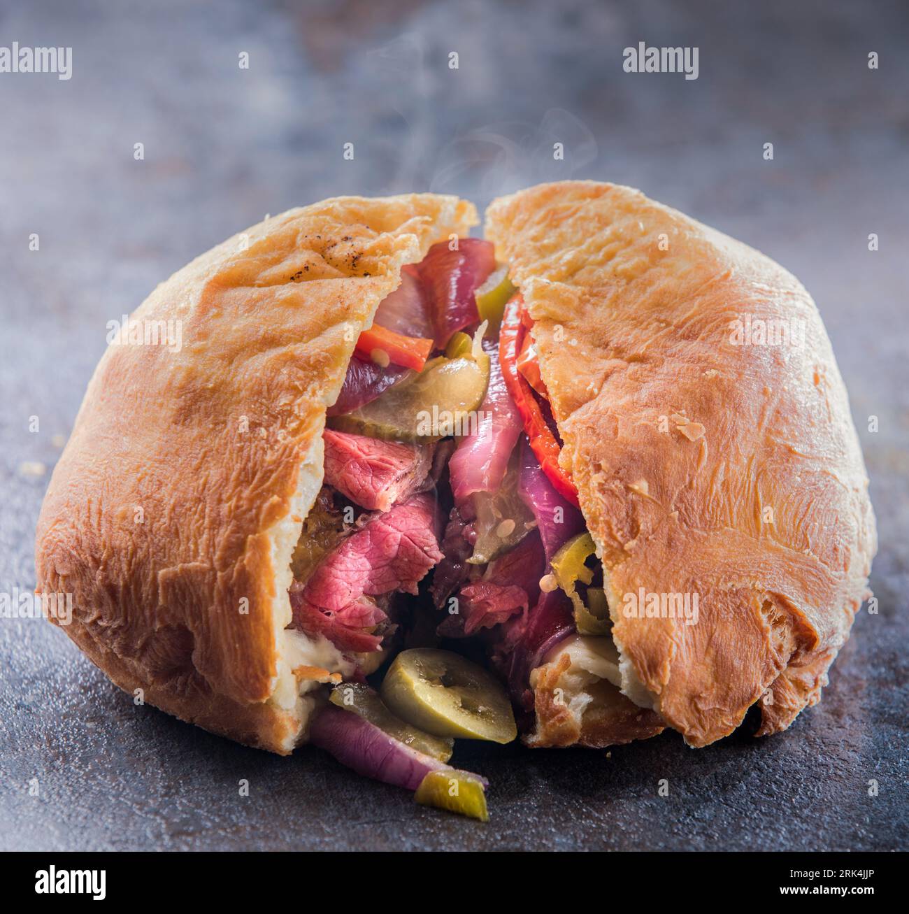 A close-up of a meat and vegetable Muffuletta sandwich sliced through ...
