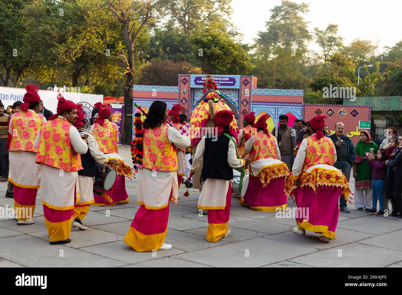 A group of traditionally dressed performers dancing outdoors during the ...
