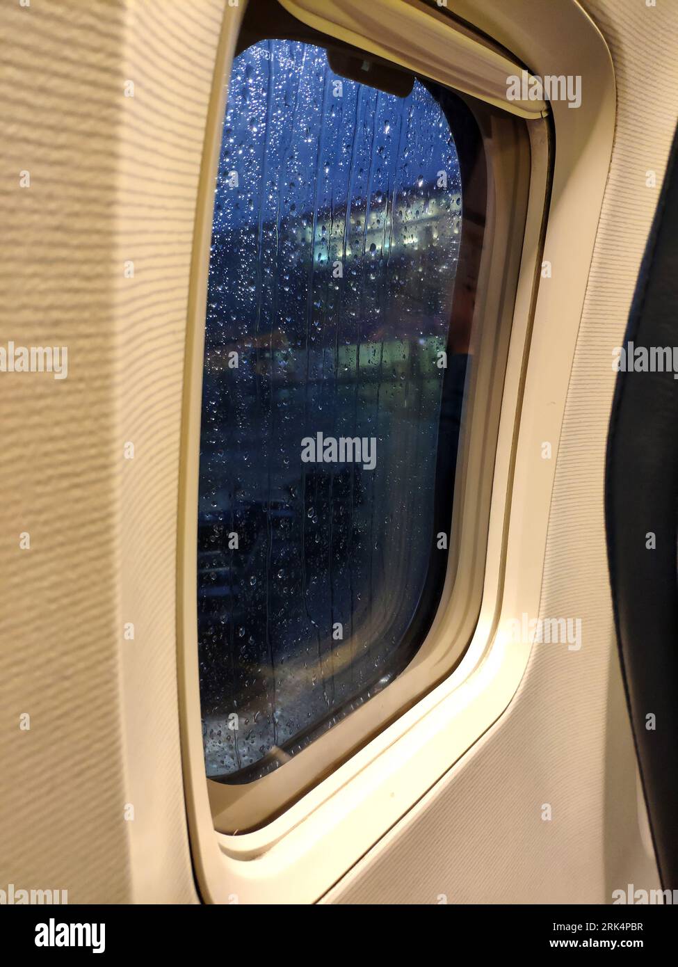 Airplane window close view. Rainy weather outside before take off Stock ...