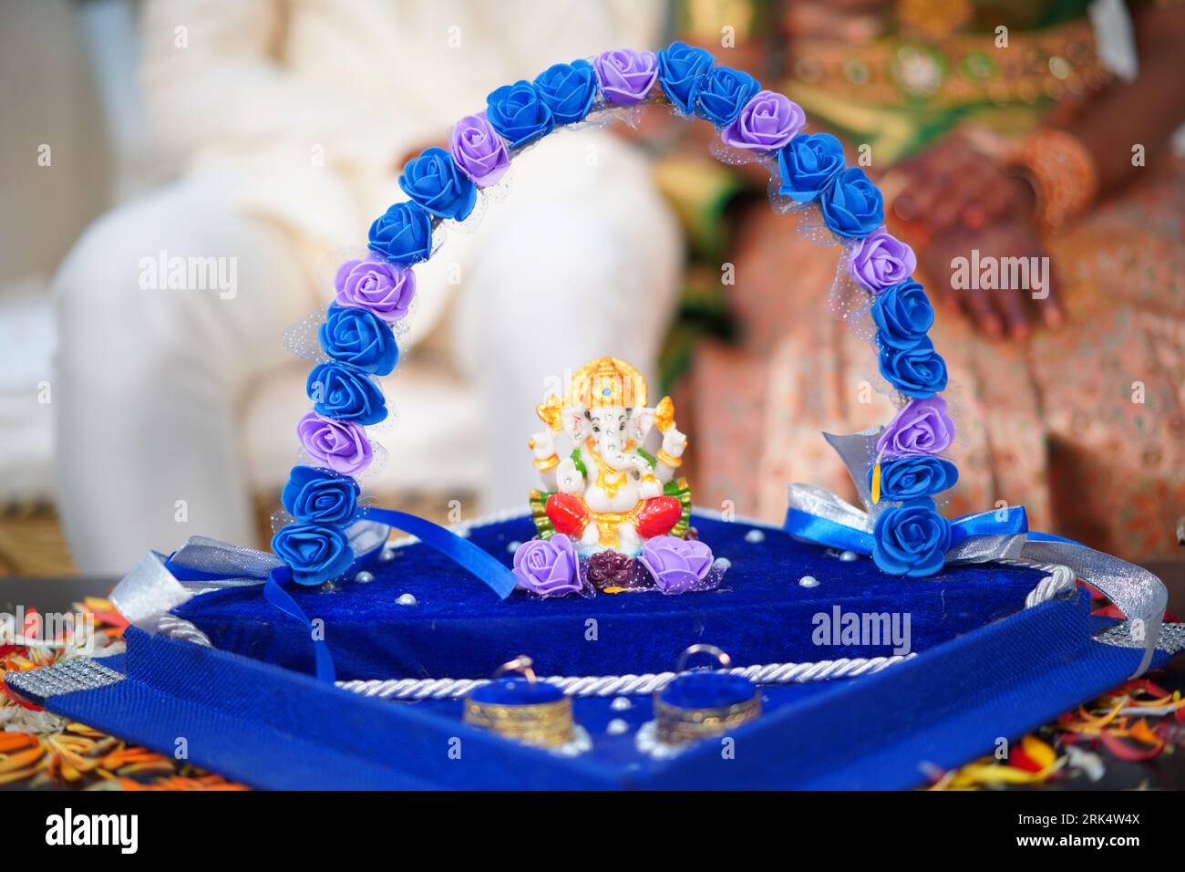 A blue Krishna god decoration with a marriage couple on the background ...