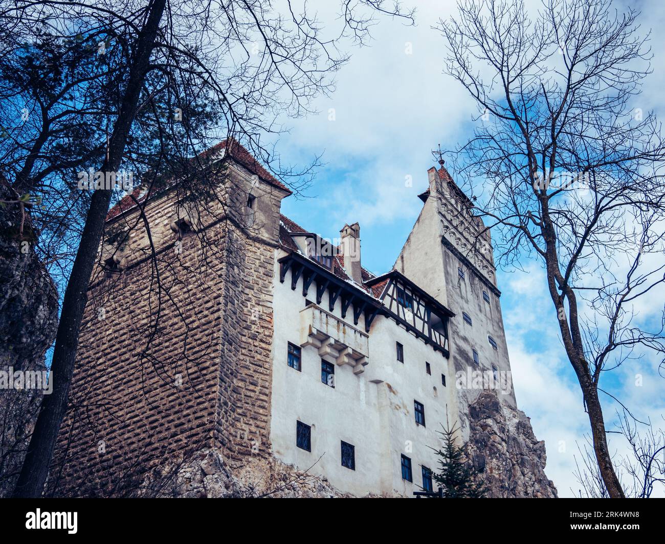 The majestic Bran castle in Romania stands in a lush, green landscape ...