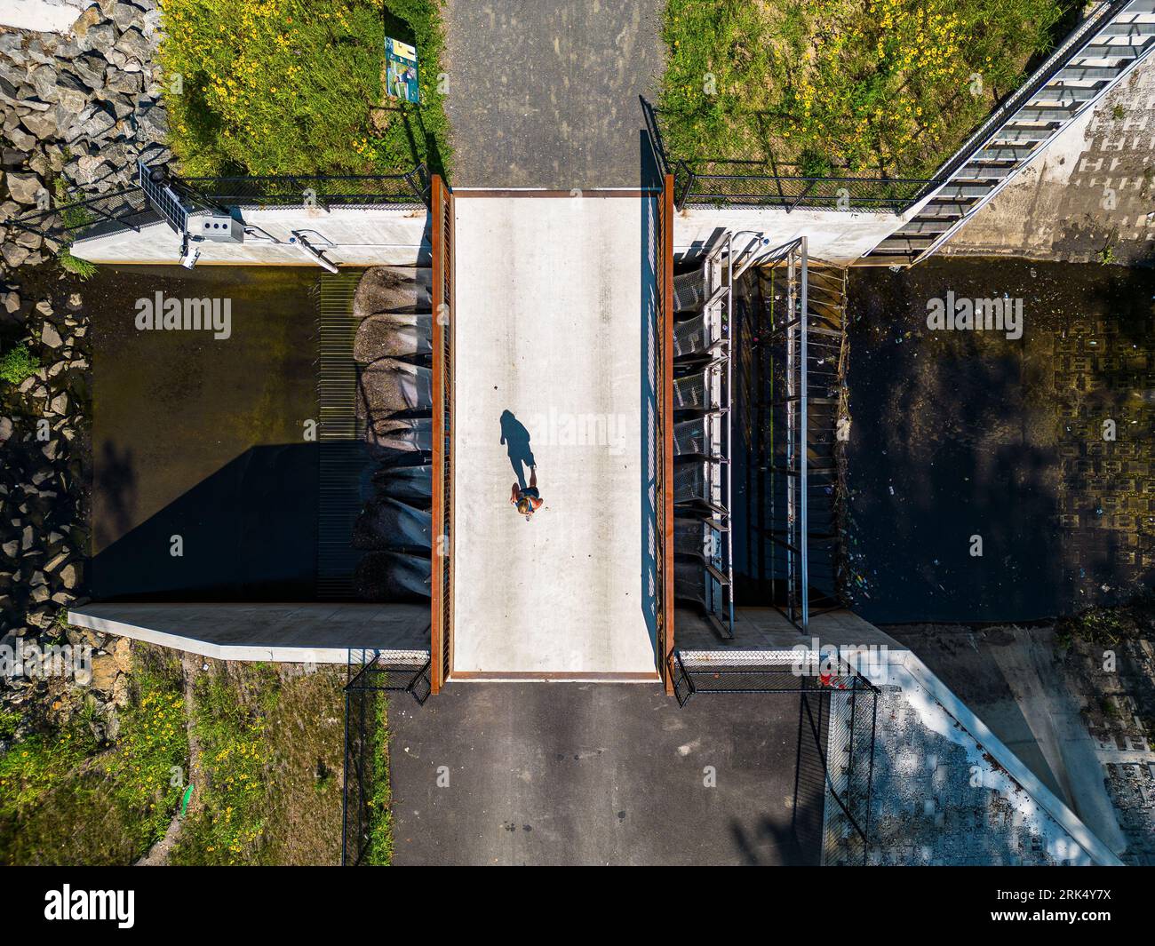 An aerial top down view directly over a footbridge over a water run off ...