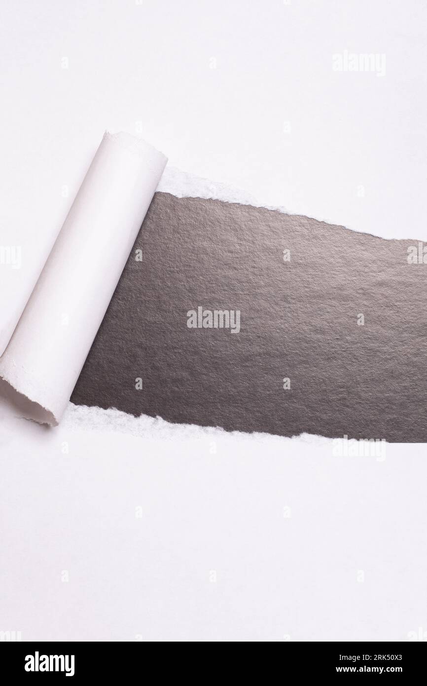 Torn paper with opening showing black background Stock Photo - Alamy