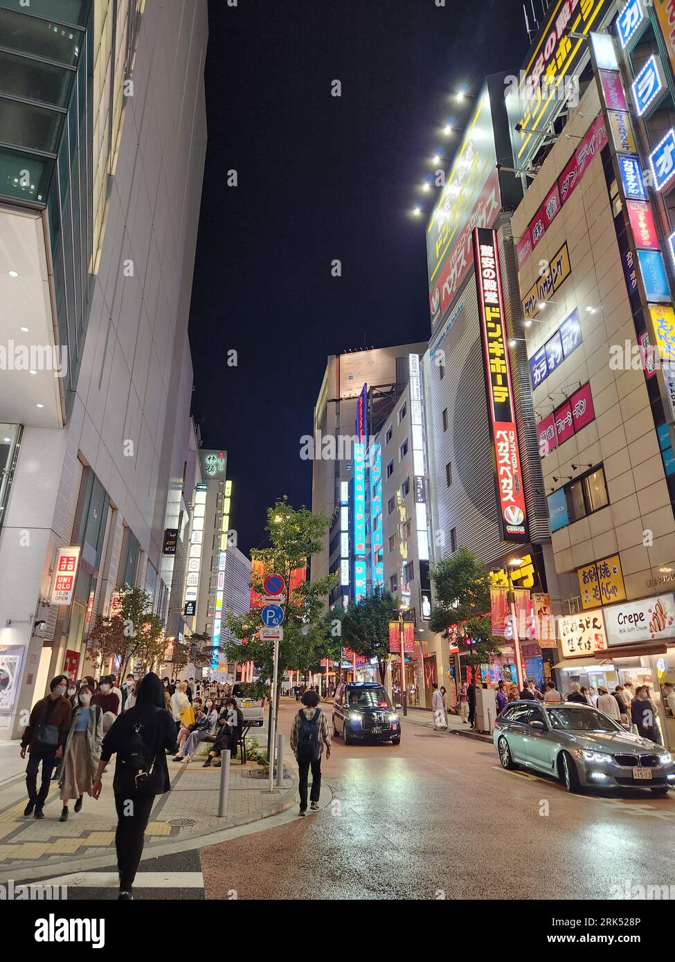 A bustling street scene filled with people. Night time in Shinjuku ...