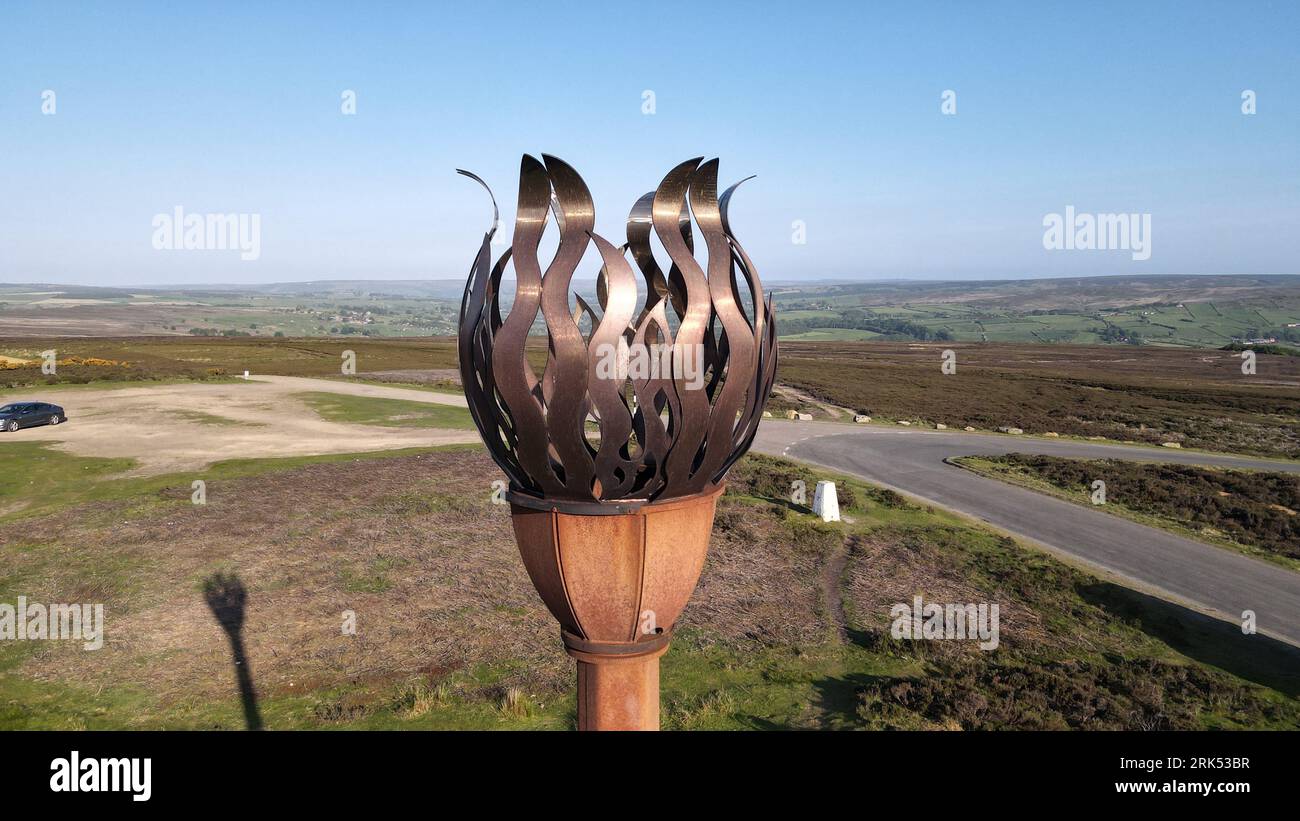 A large metallic sculpture of a torch is prominently displayed atop a ...