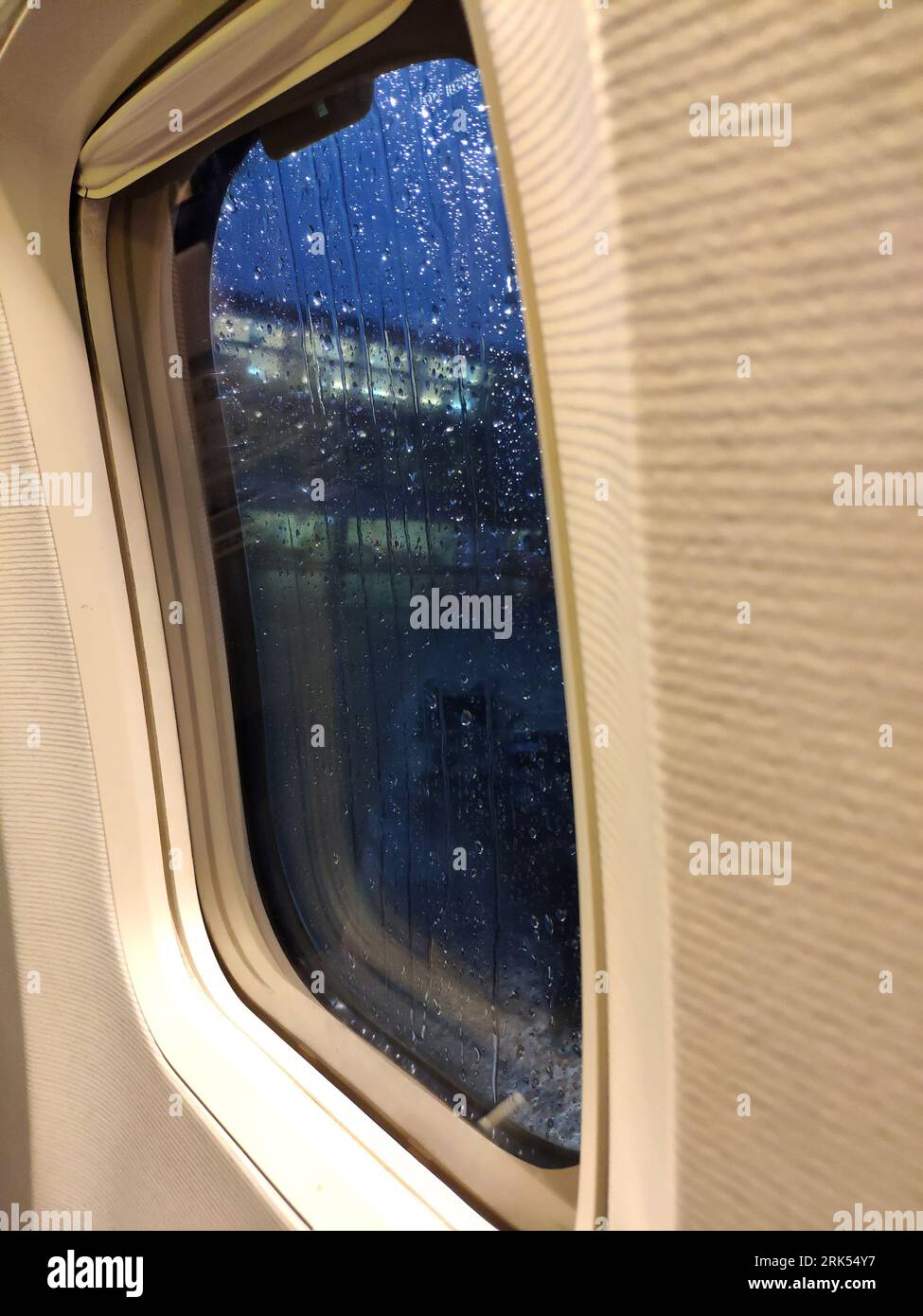 Airplane window close view. Rainy weather outside before take off Stock ...