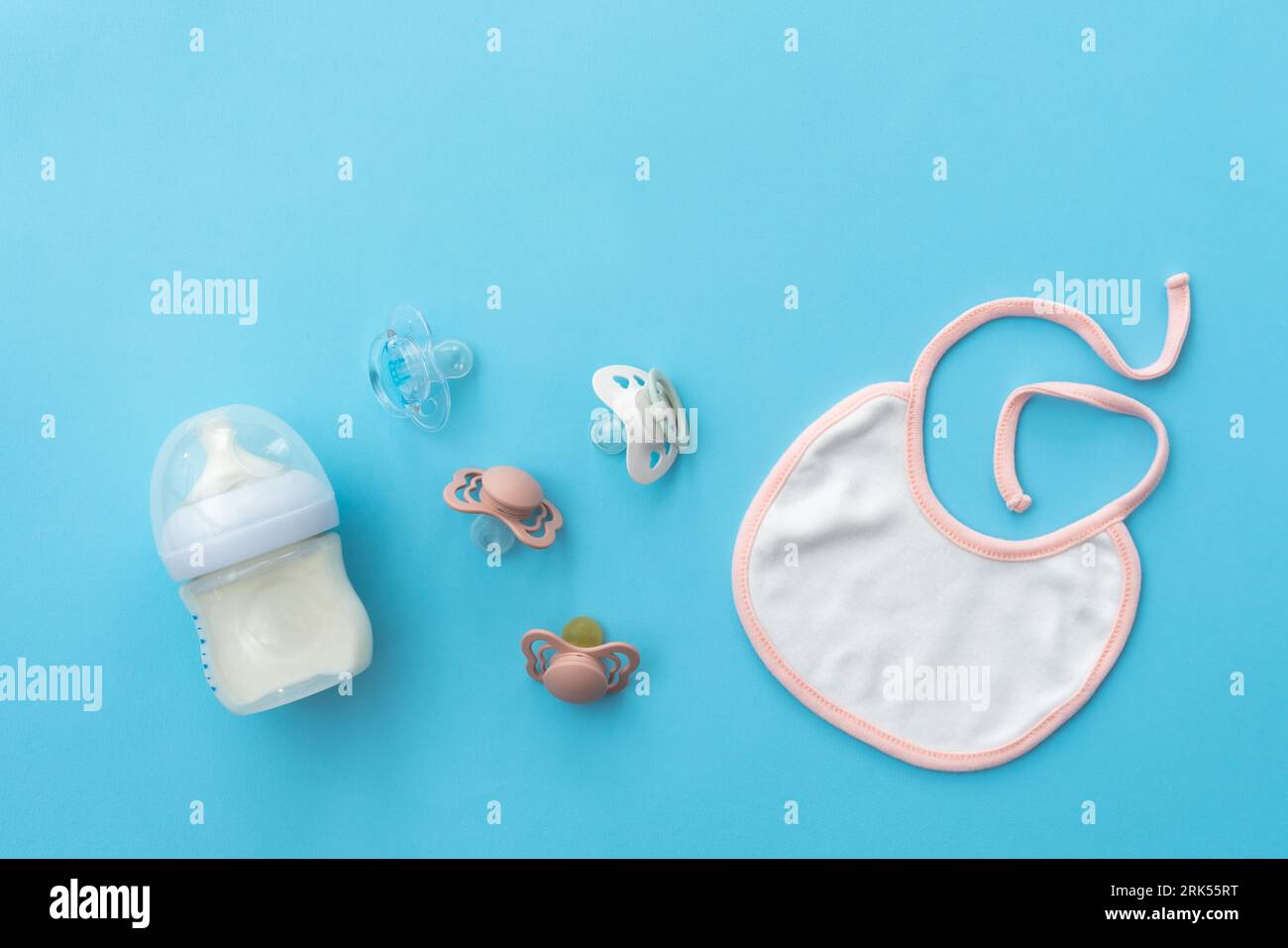 Top-down view of baby essentials with pacifiers on soft blue, offering ...