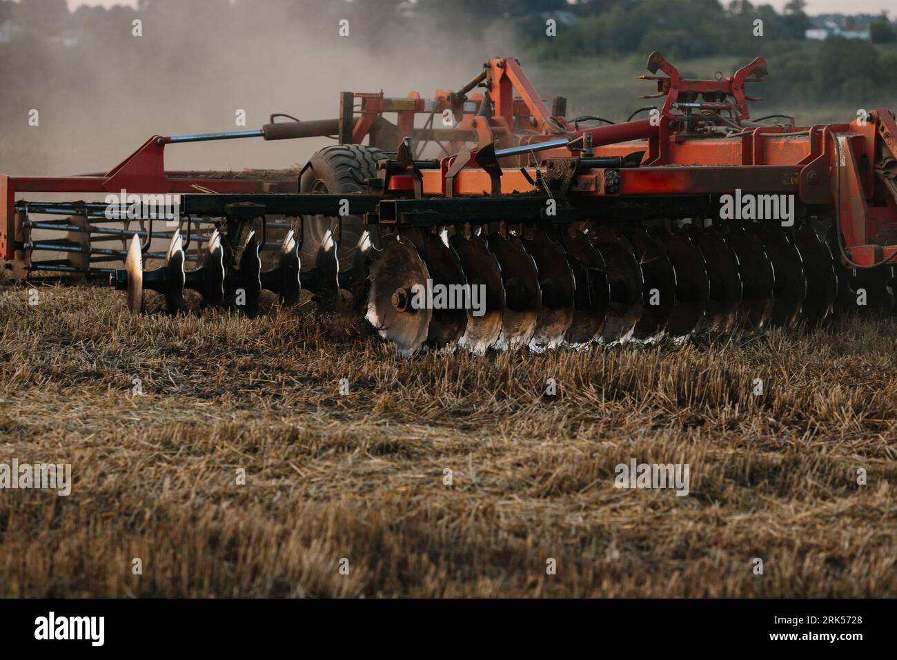 A tractor with a large disc harrow for tillage. Farmer work concept ...