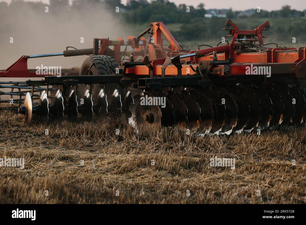 A tractor with a large disc harrow for tillage. Farmer work concept ...