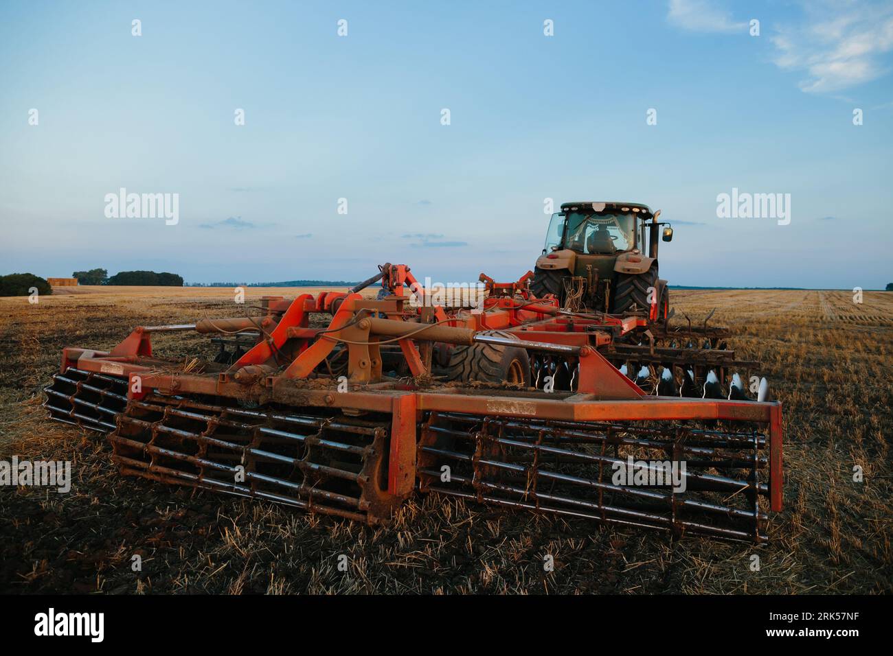 A tractor with a large disc harrow for tillage. Farmer work concept ...