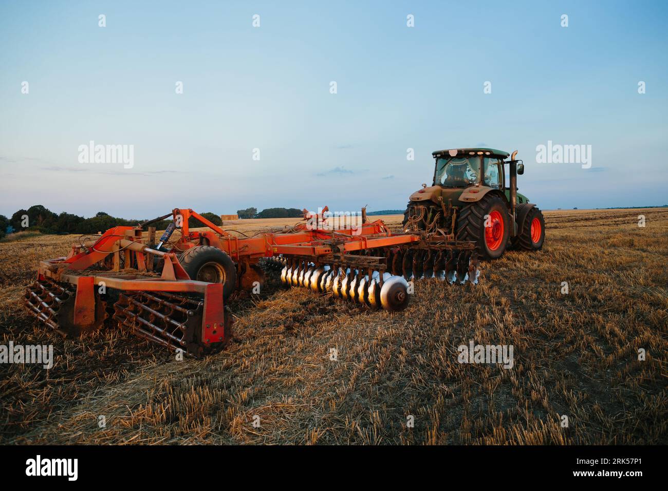 A tractor with a large disc harrow for tillage. Farmer work concept ...