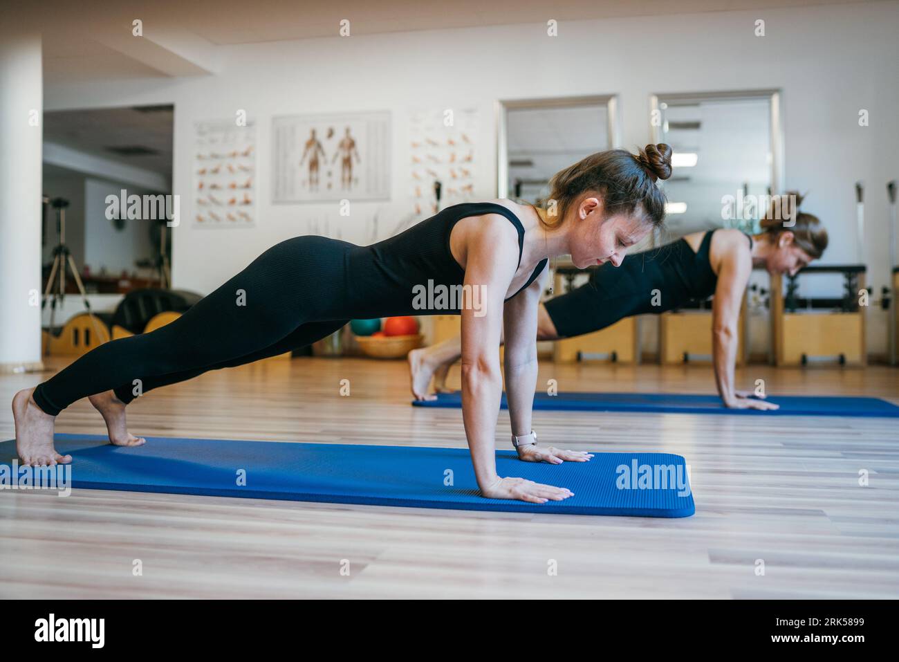 Two young females doing extended plank static strengthening core ...