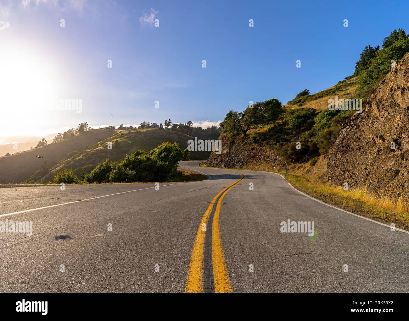 A serene empty road with golden yellow painted lane markings along the ...