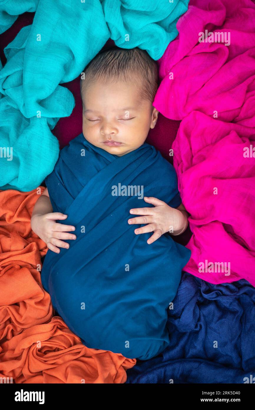 cute newborn baby sleeping in baby wrap in unique style from top angle ...