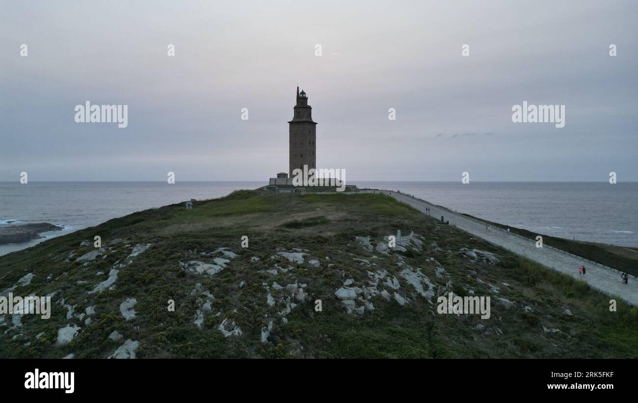 An old Hercules Tower lighthouse standing tall on a rocky hill ...