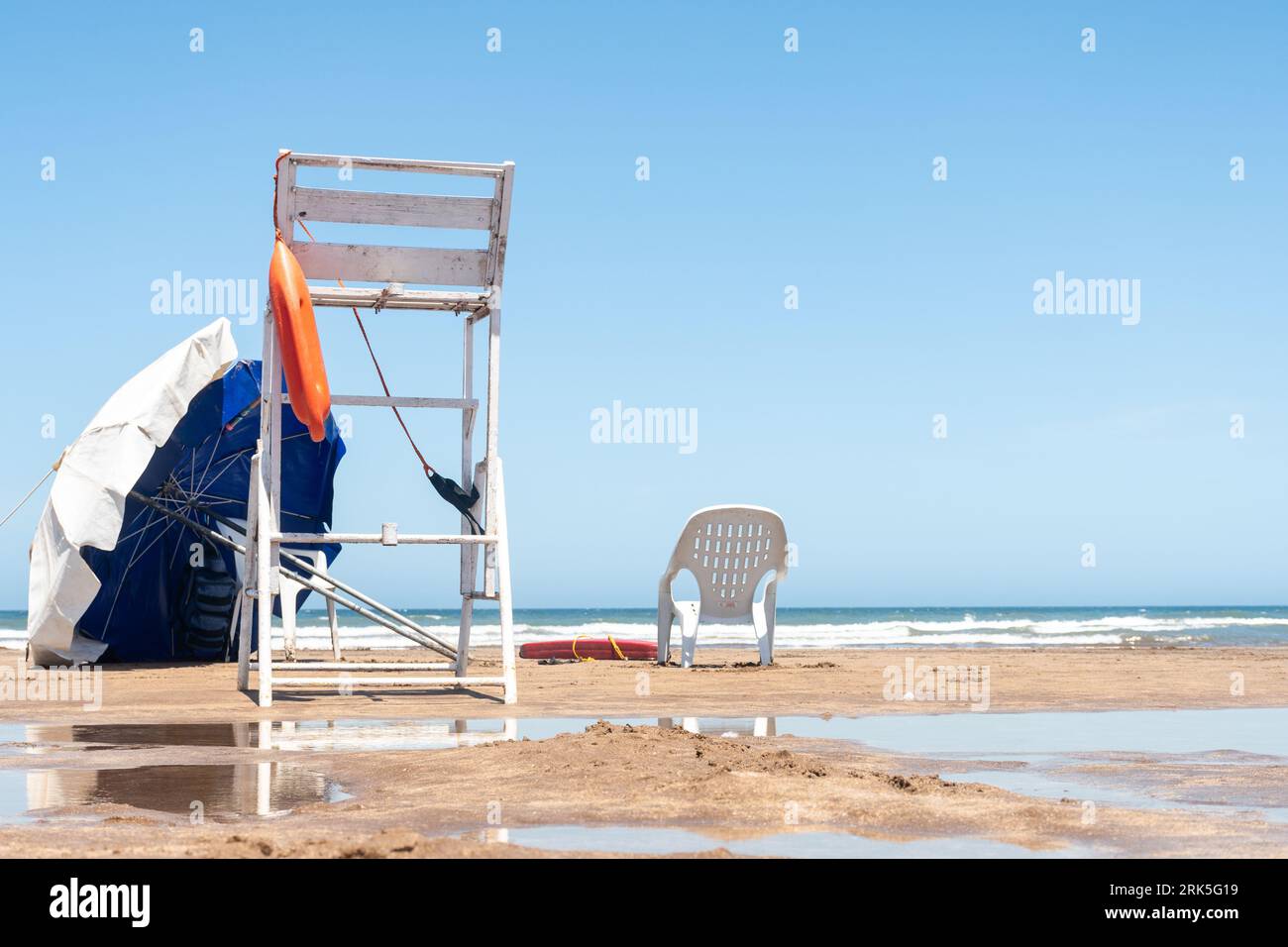 Empty lifeguard station on the beach with chair and umbrella. Copy ...