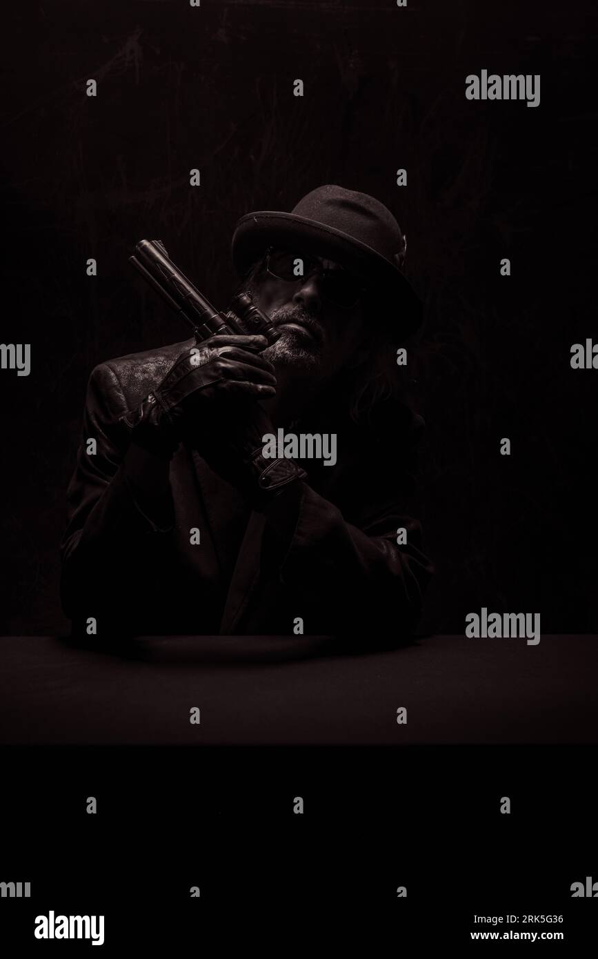 A dramatic portrait of a gangster holding a gun Stock Photo - Alamy