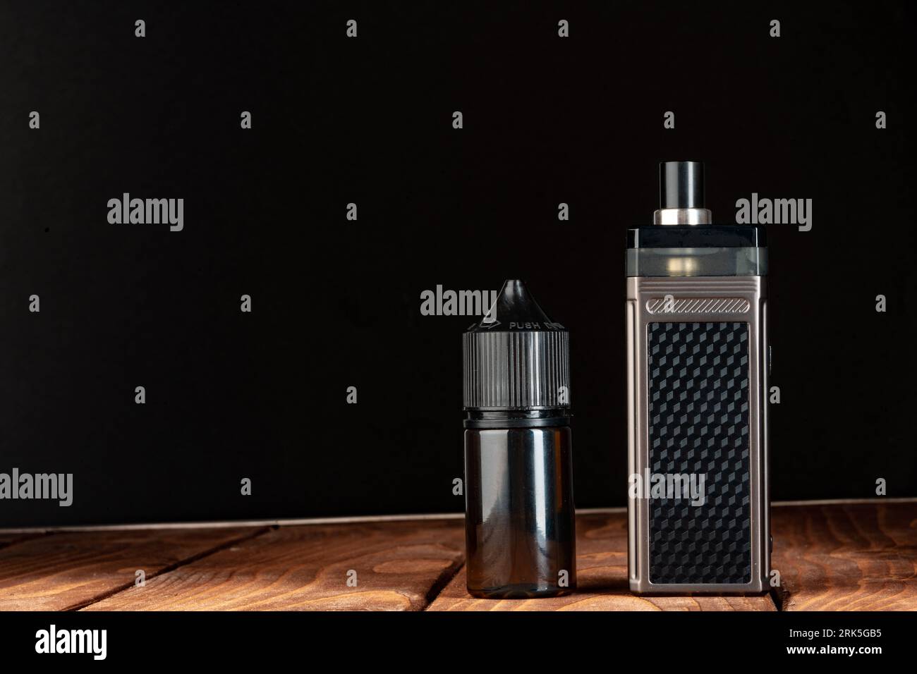 Vape and vape liquid bottles against black background Stock Photo - Alamy